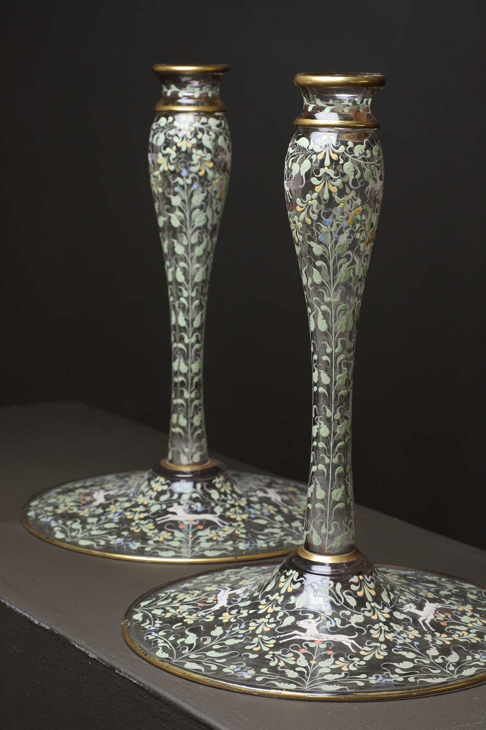 Lot 521 - A pair of Moser enamelled glass candlesticks,